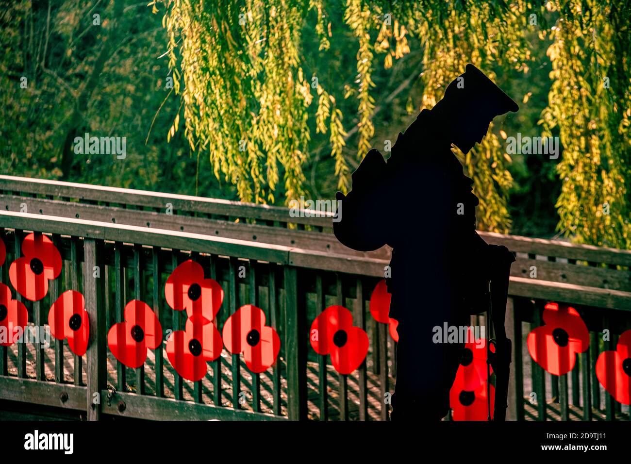 A cast iron silhouette of a soldier with head bowed and a footbridge ...