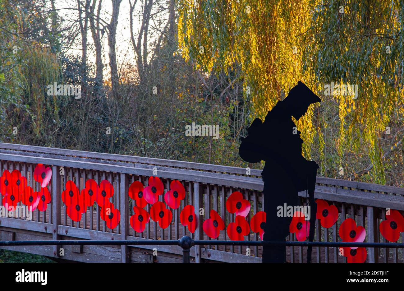 A cast iron silhouette of a soldier with head bowed and a footbridge ...
