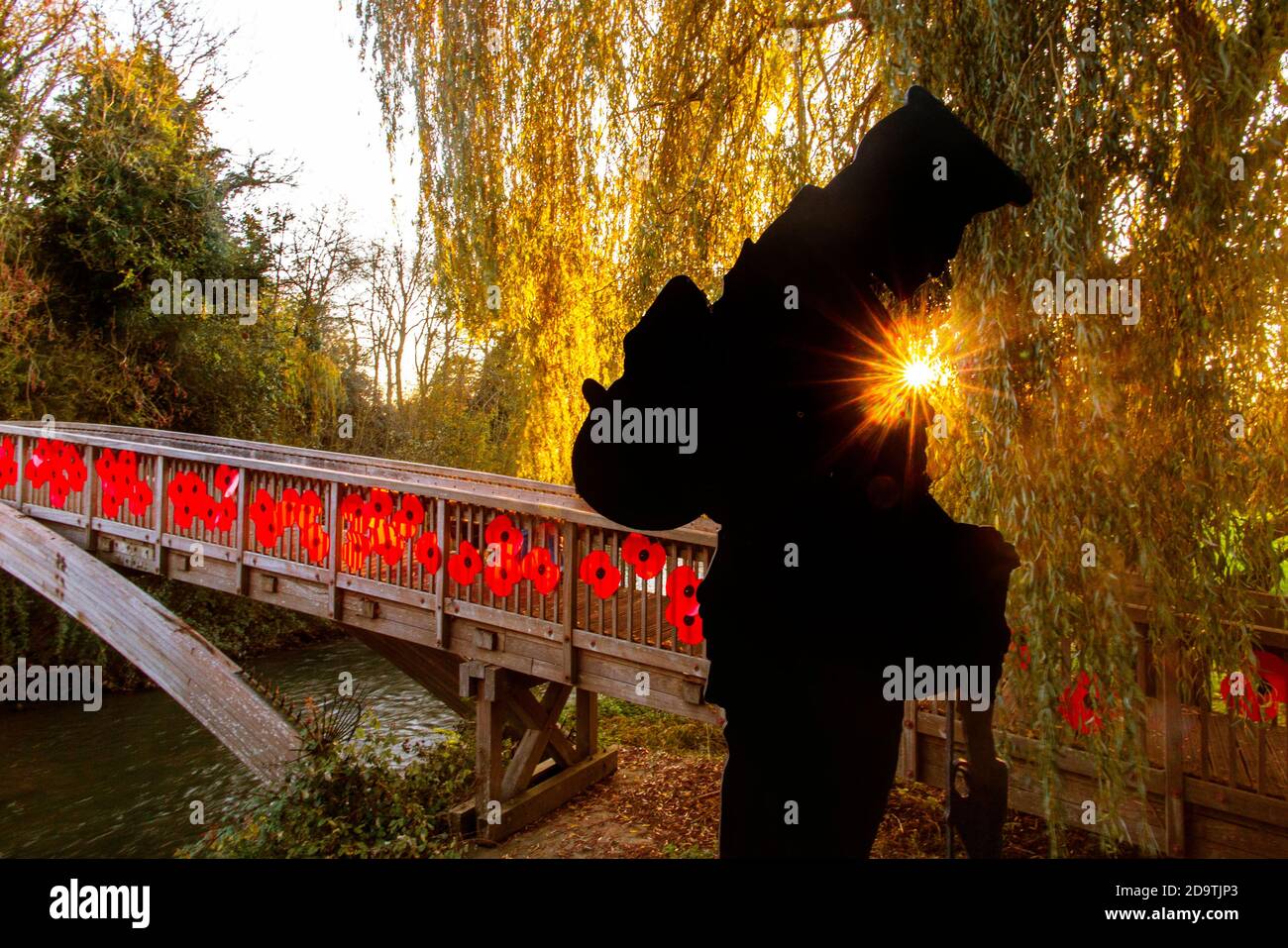 A cast iron silhouette of a soldier with head bowed and a footbridge ...