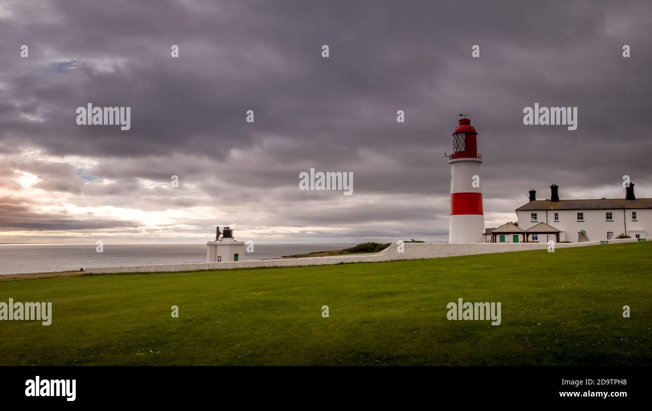 Souter Lighthouse against dramatic lighting and sky at Marsden Village ...