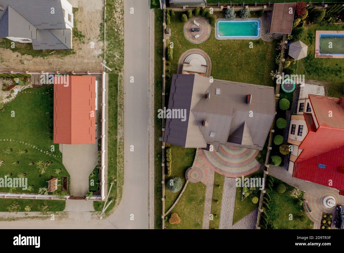 Aerial top view of a private house with paved yard with green grass ...