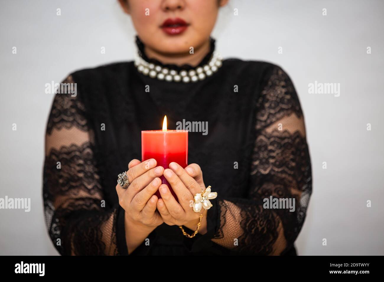 A picture of a woman holding a candle to perform magic rituals and ...