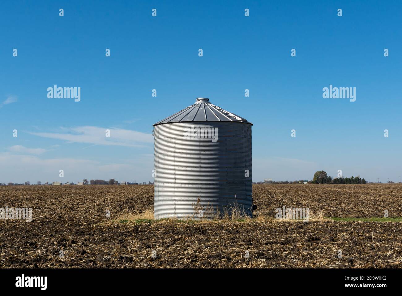 Solitary grain silo on a barren field in the late fall sunshine. Rural ...