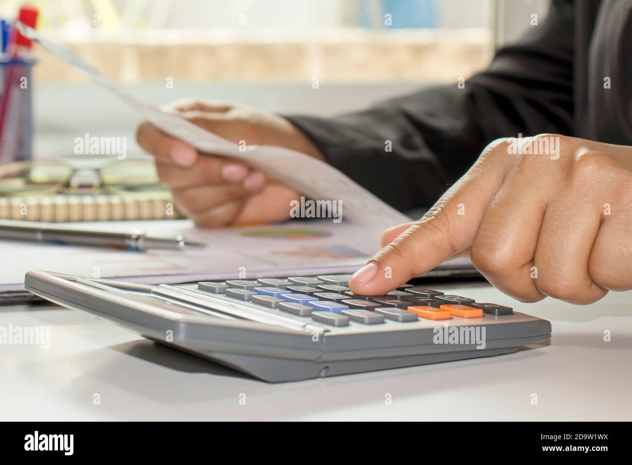 The businessman's hand is pressing a calculator, doing finance work and ...