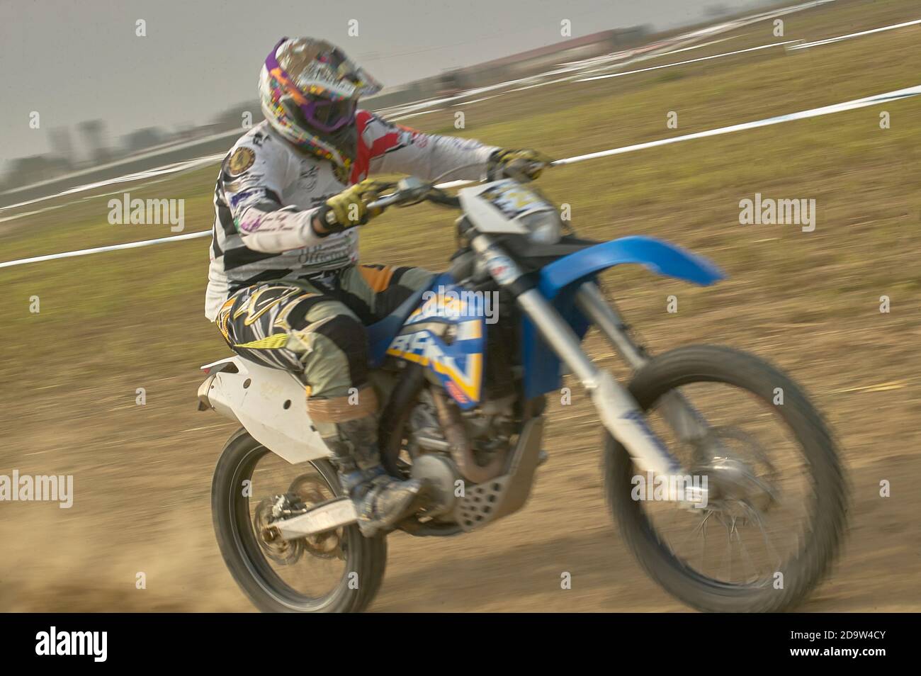 Motocross rider intent on driving his motorbike to the finish line in a ...