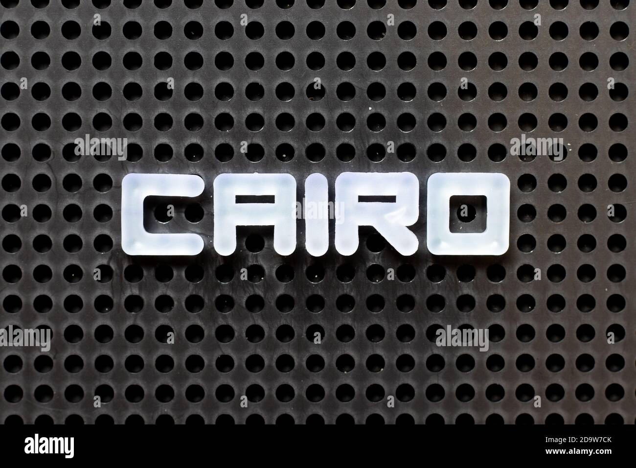 White color alphabet with word cairo on black pegboard background Stock ...