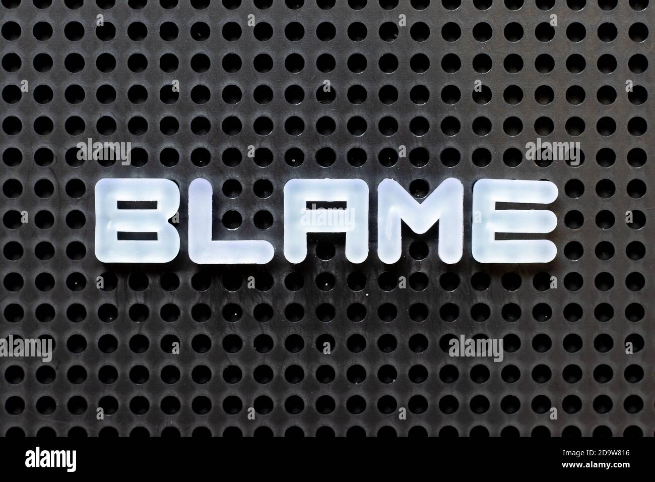 White color alphabet with word blame on black pegboard background Stock ...
