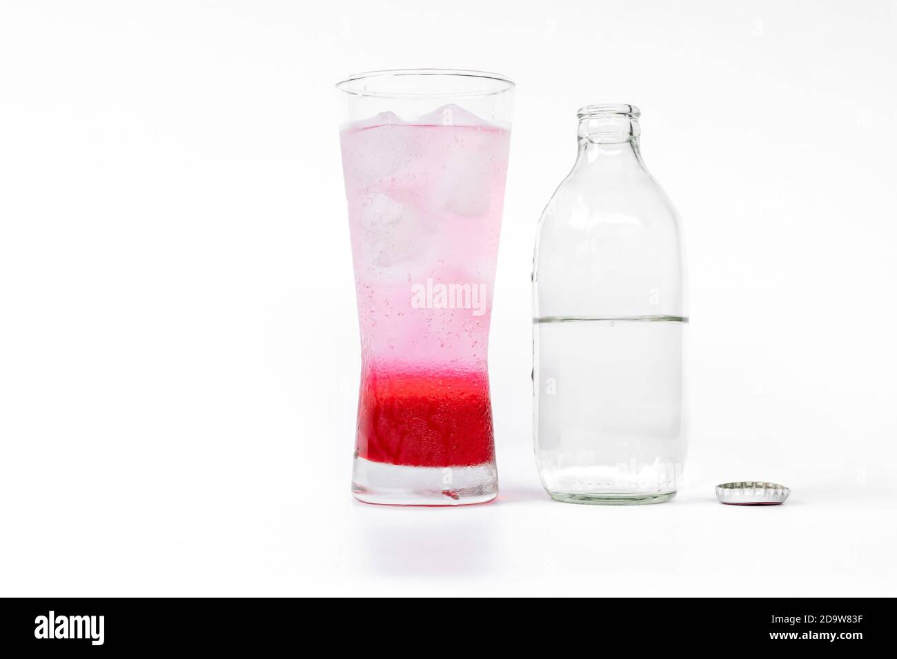 Glass of red nectar mixed with soda and soda bottles that open the lid ...