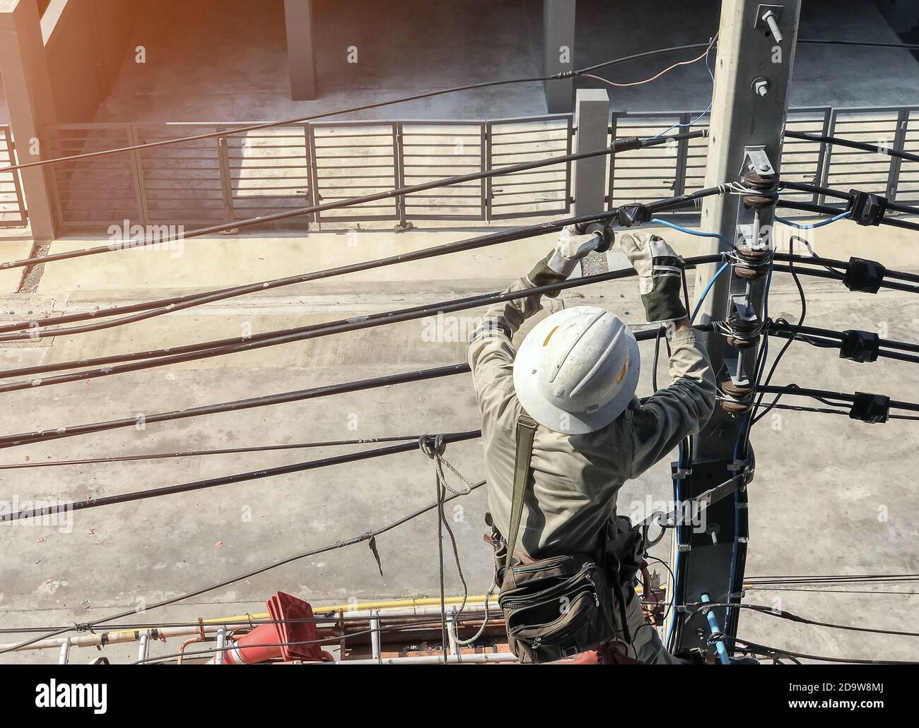 Electricians are climbing on electric poles to install power lines ...