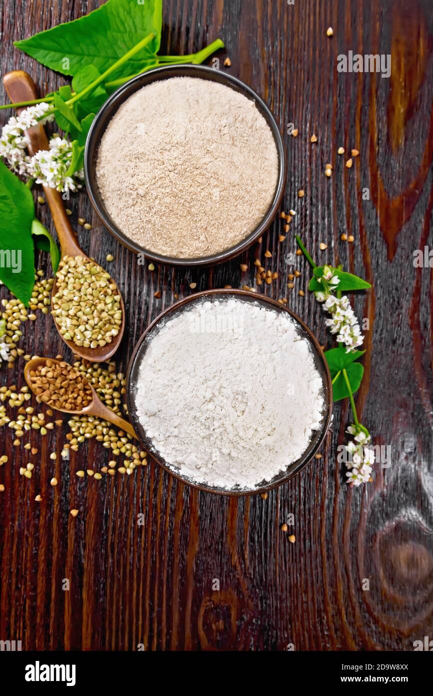 Buckwheat flour from green and brown cereals in two bowls, groats in ...