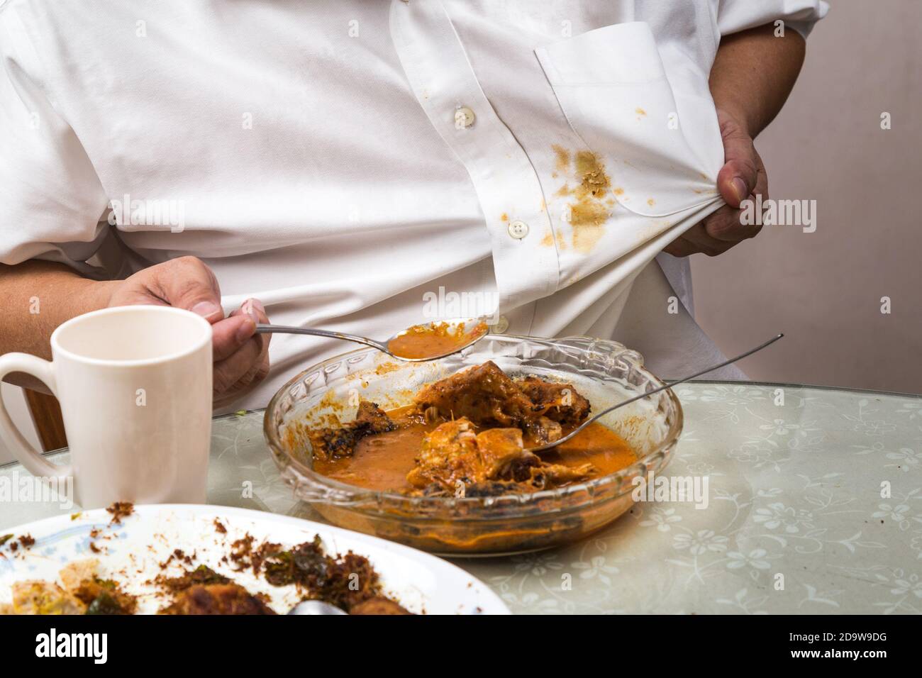 Person accidently spilled curry stain onto white shirt Stock Photo - Alamy