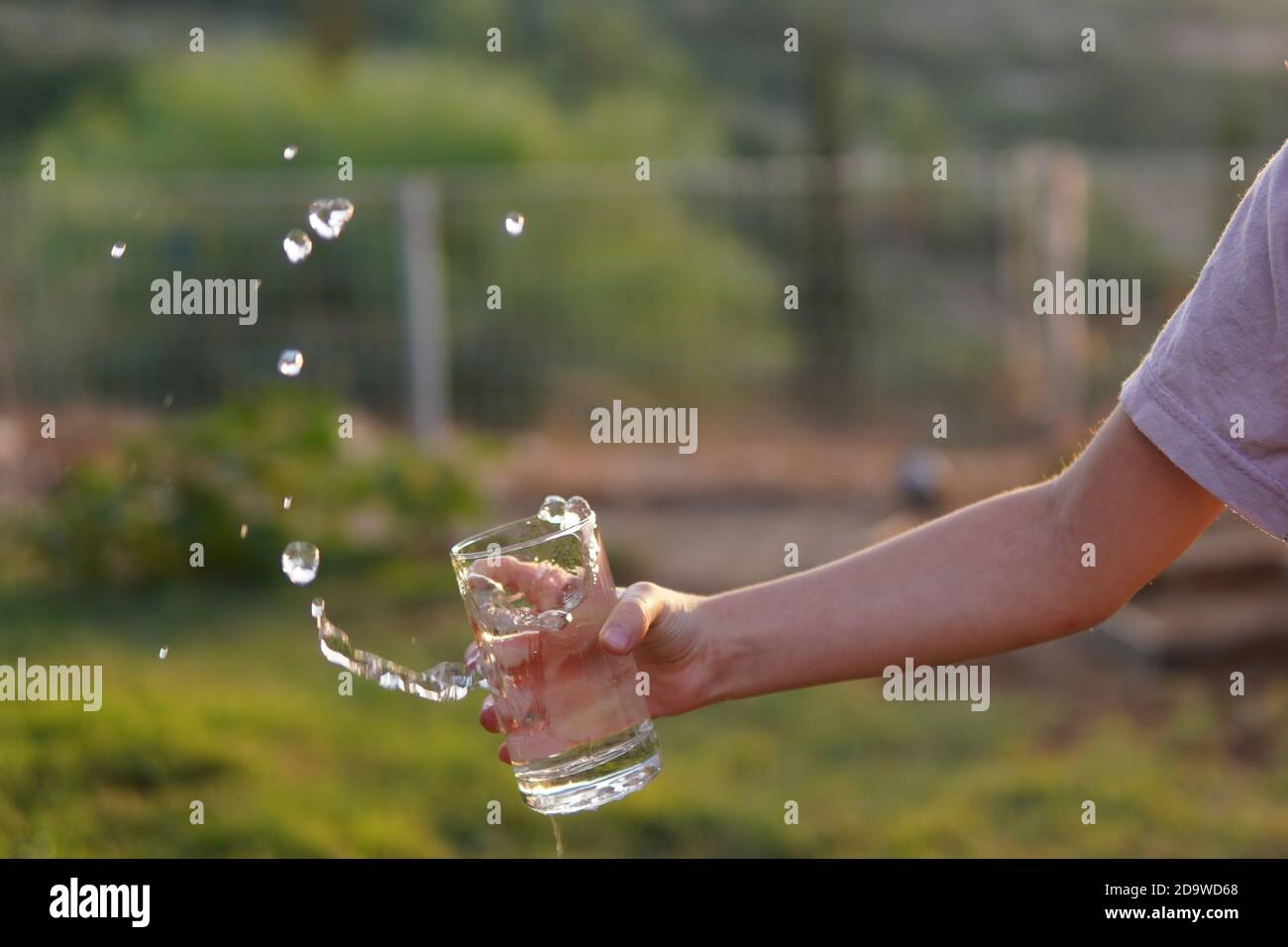 girl spilling water from glass Stock Photo - Alamy