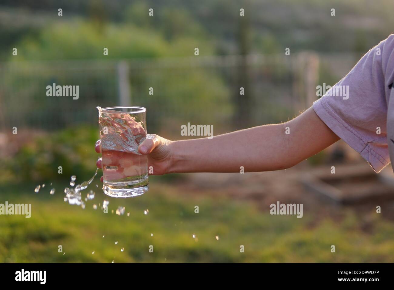 girl spilling water from glass Stock Photo - Alamy