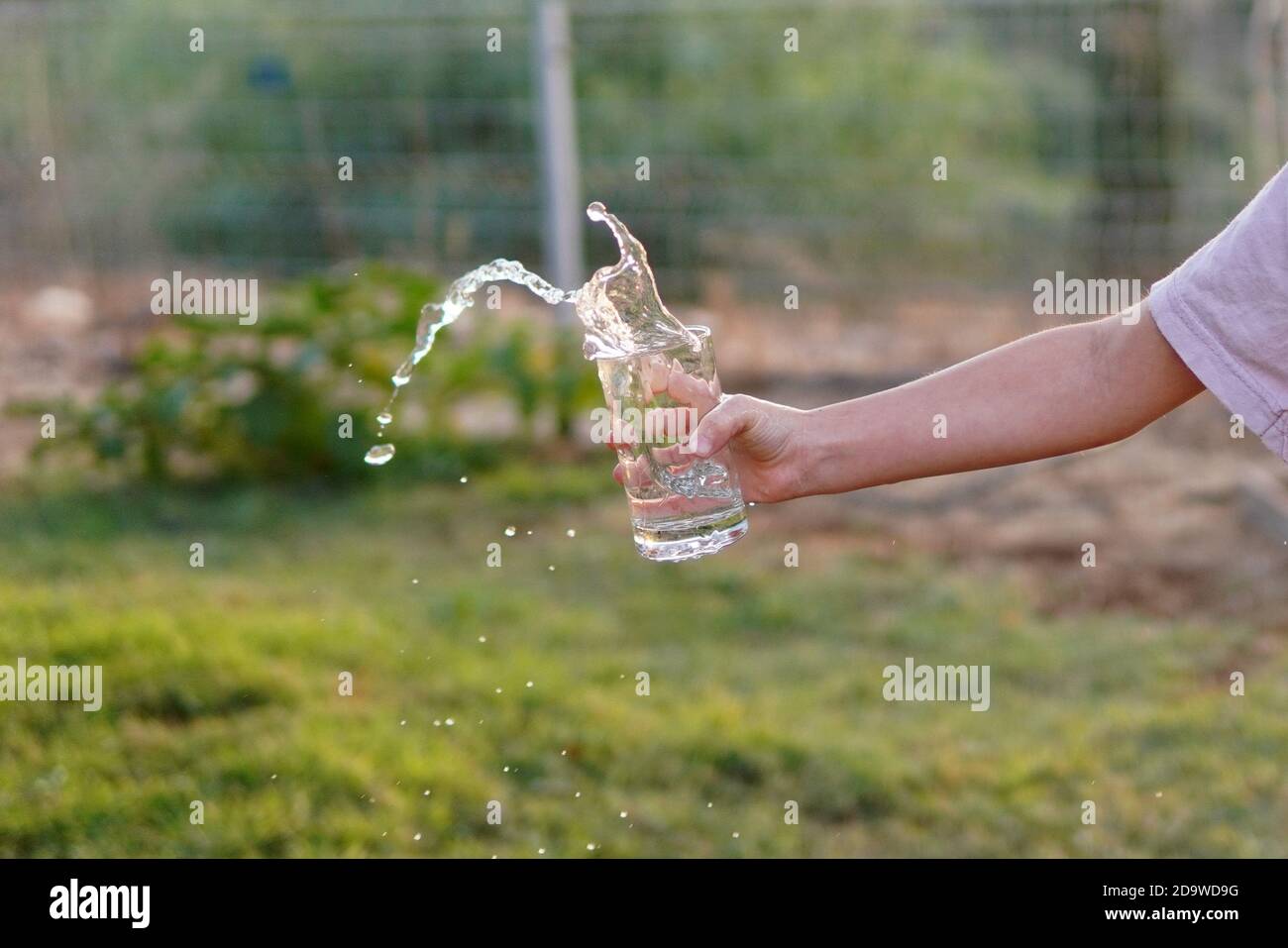 girl spilling water from glass Stock Photo - Alamy