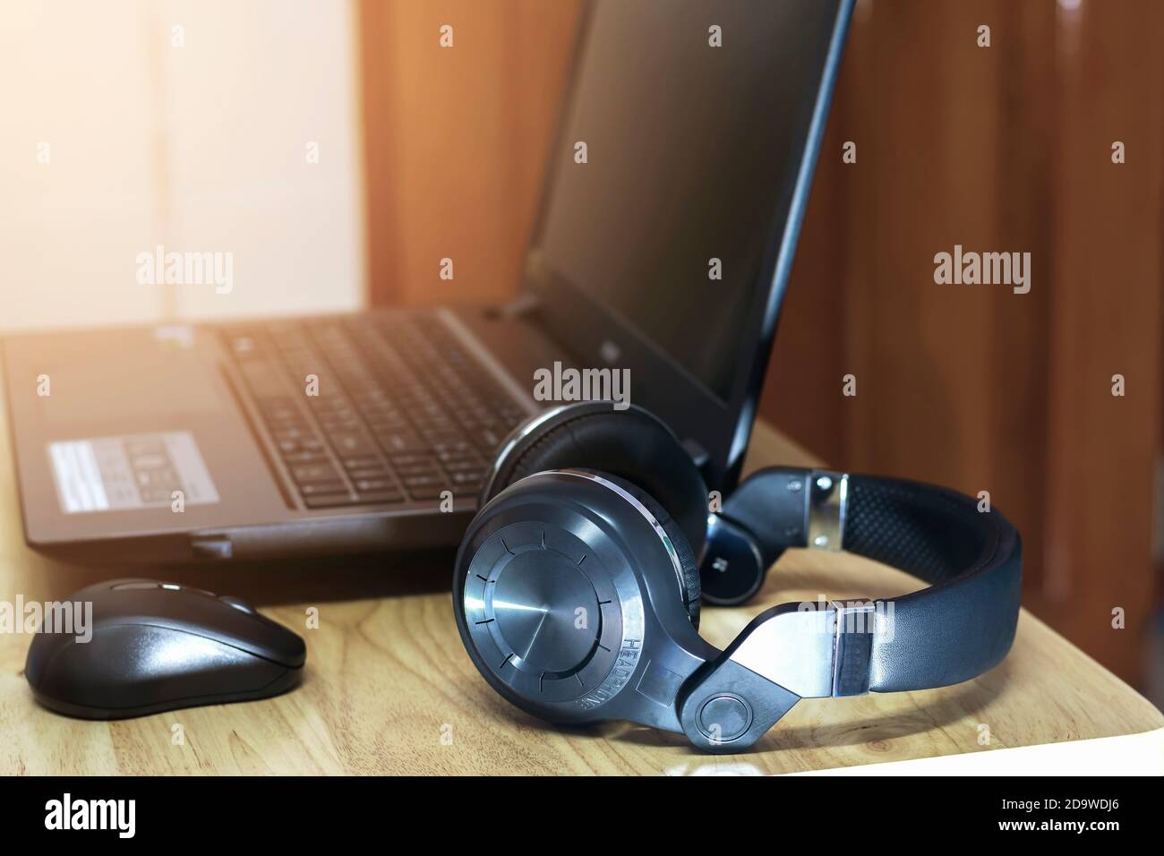 Closeup a headphone on the wooden table with a wireless mouse and ...