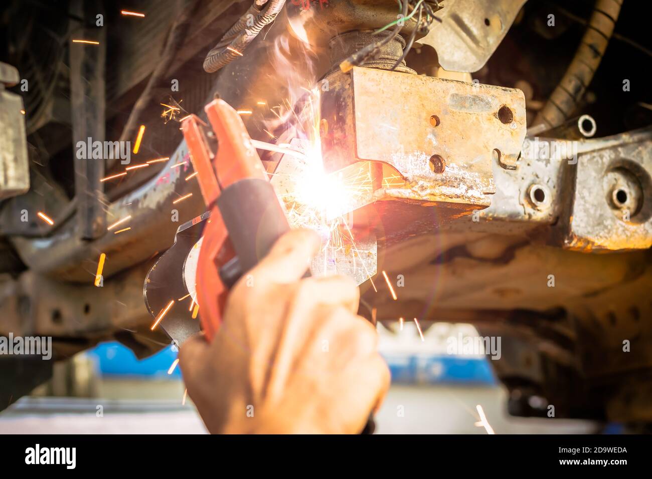 Technician are welding assembly steel under the car in automotive ...