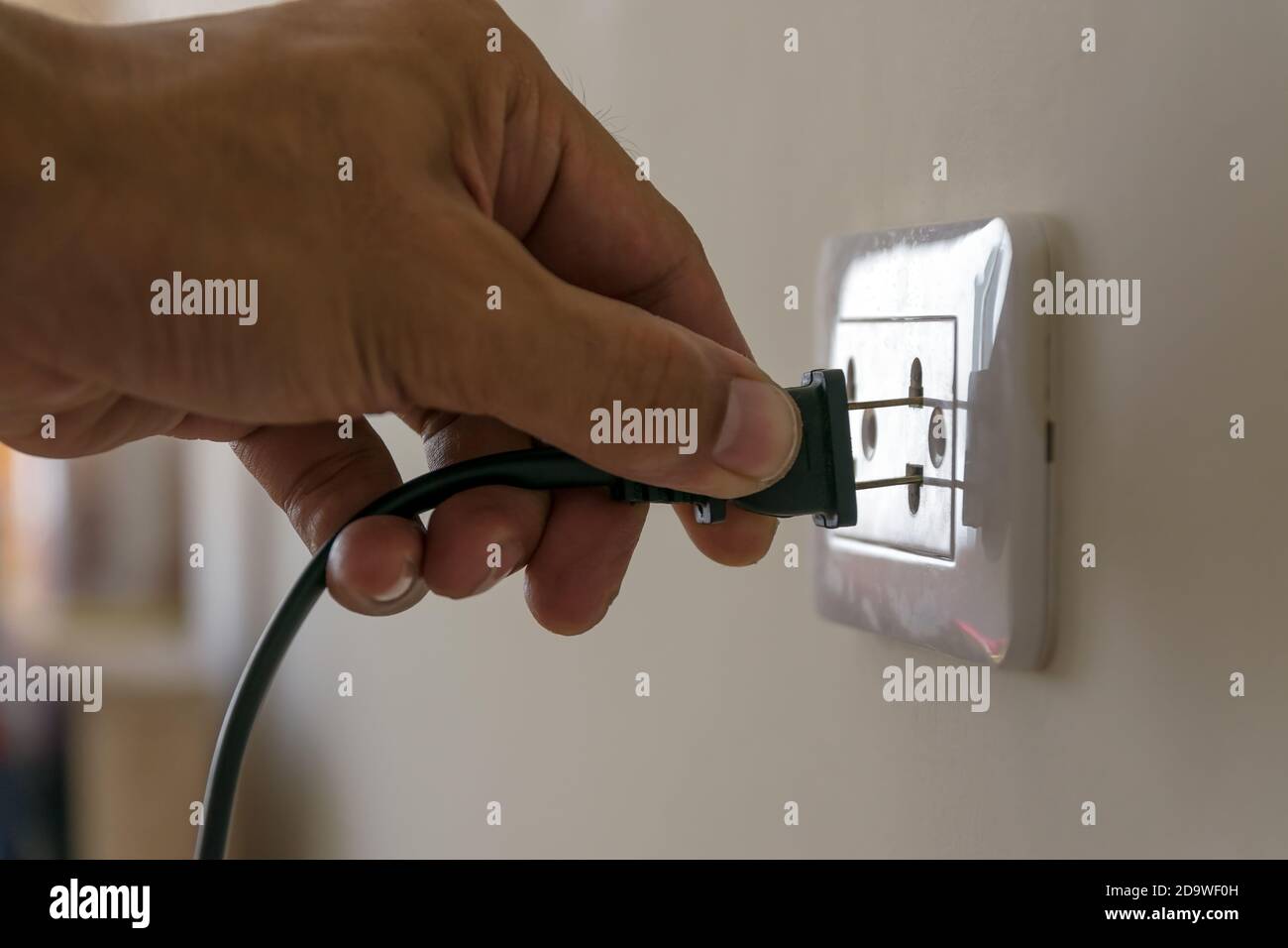 Men's hands are plugged in the power cord on the wall Stock Photo - Alamy