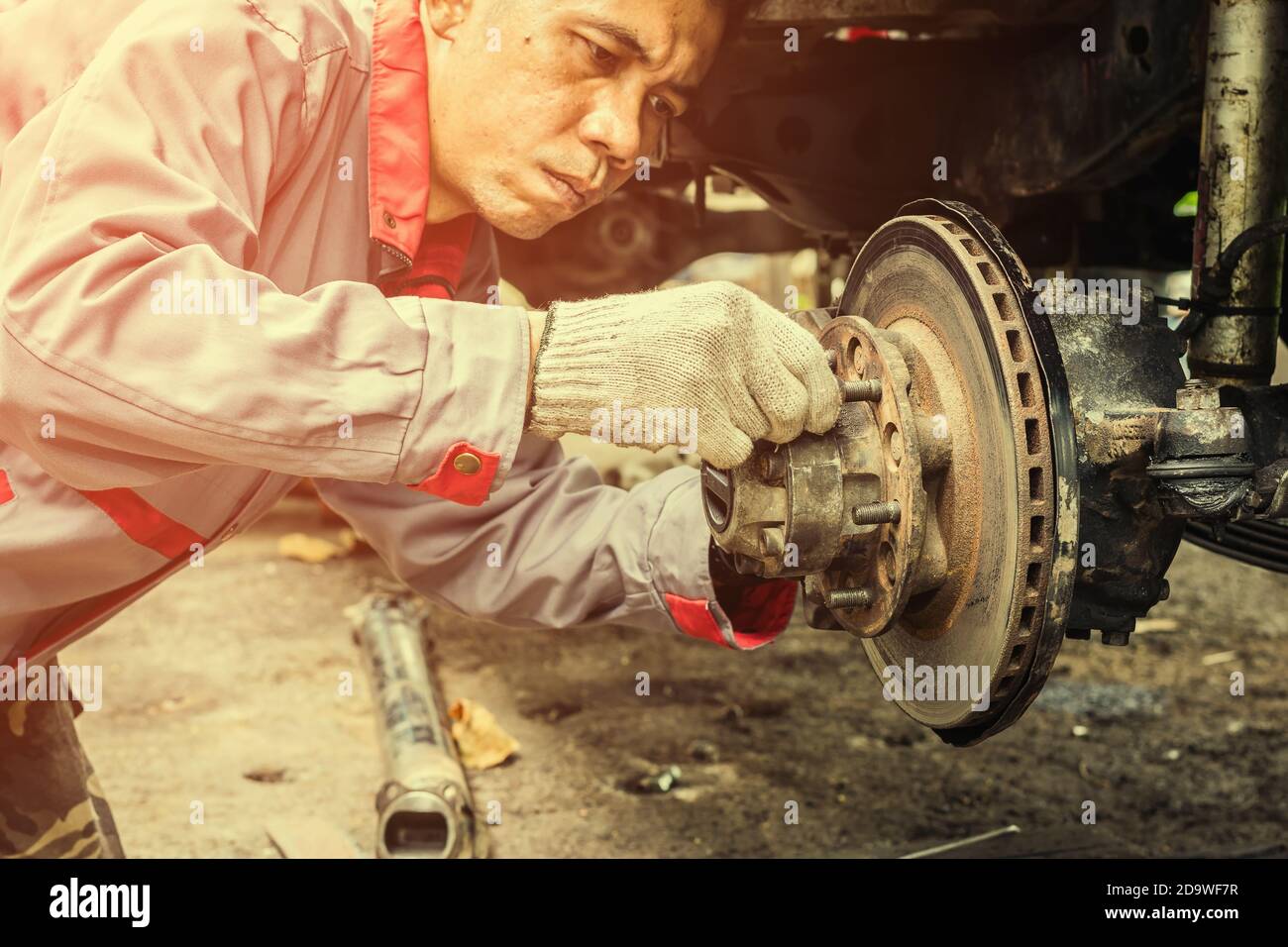Technicians in grey uniform are repairing the brake of the car ...