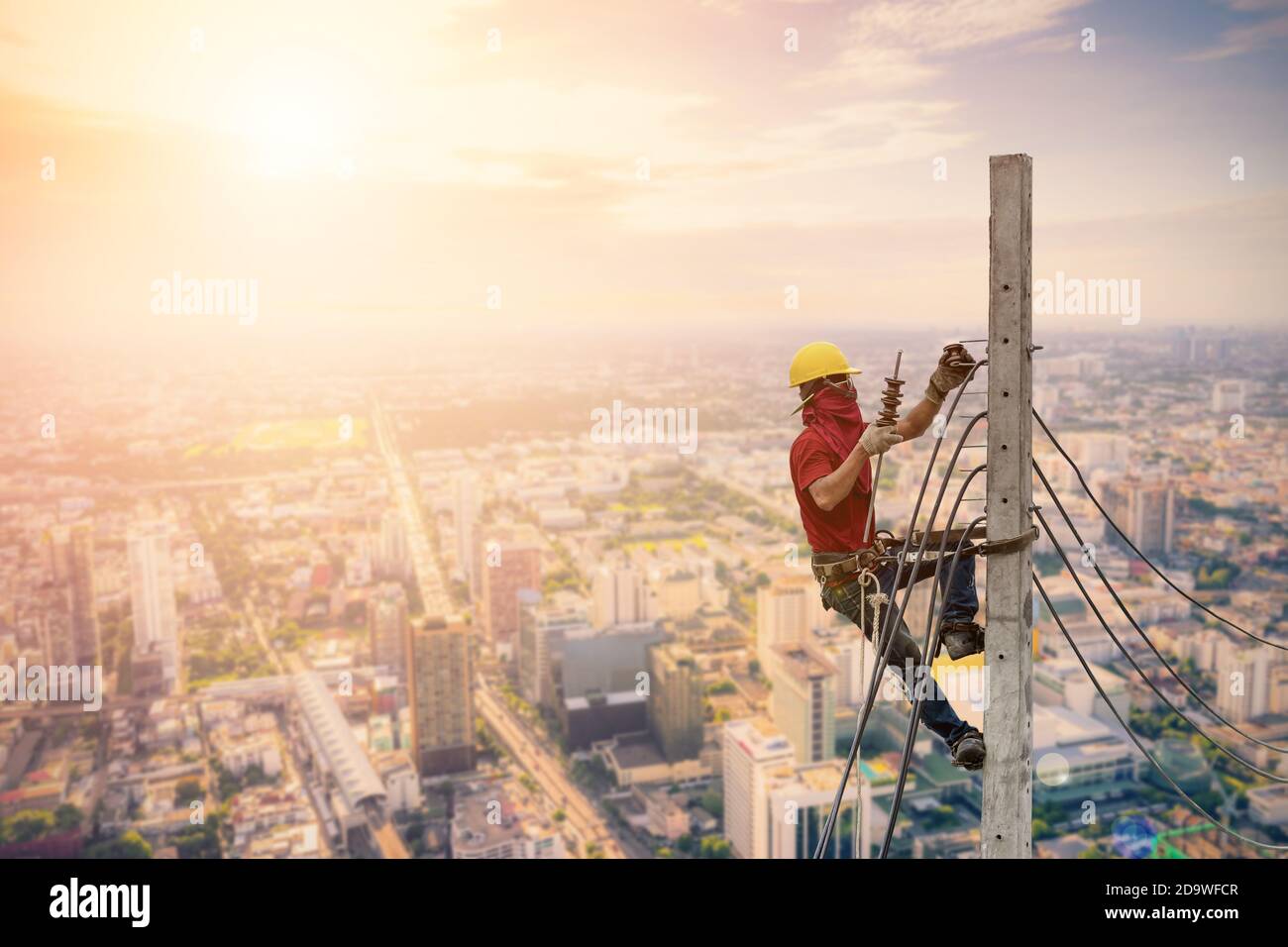Electricians are climbing on electric poles to install power lines ...