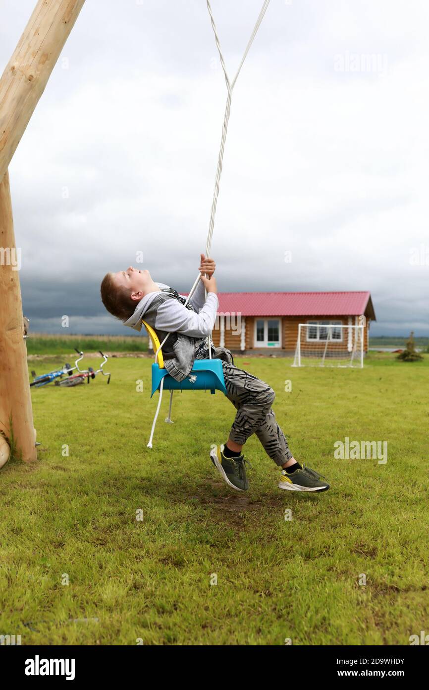 Child swinging on swing at outdoor playground Stock Photo - Alamy