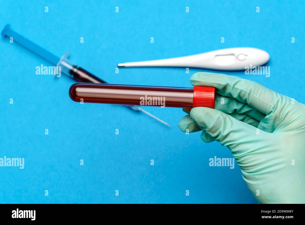 lab technician assistant or doctor holding a blood sample in test tube ...