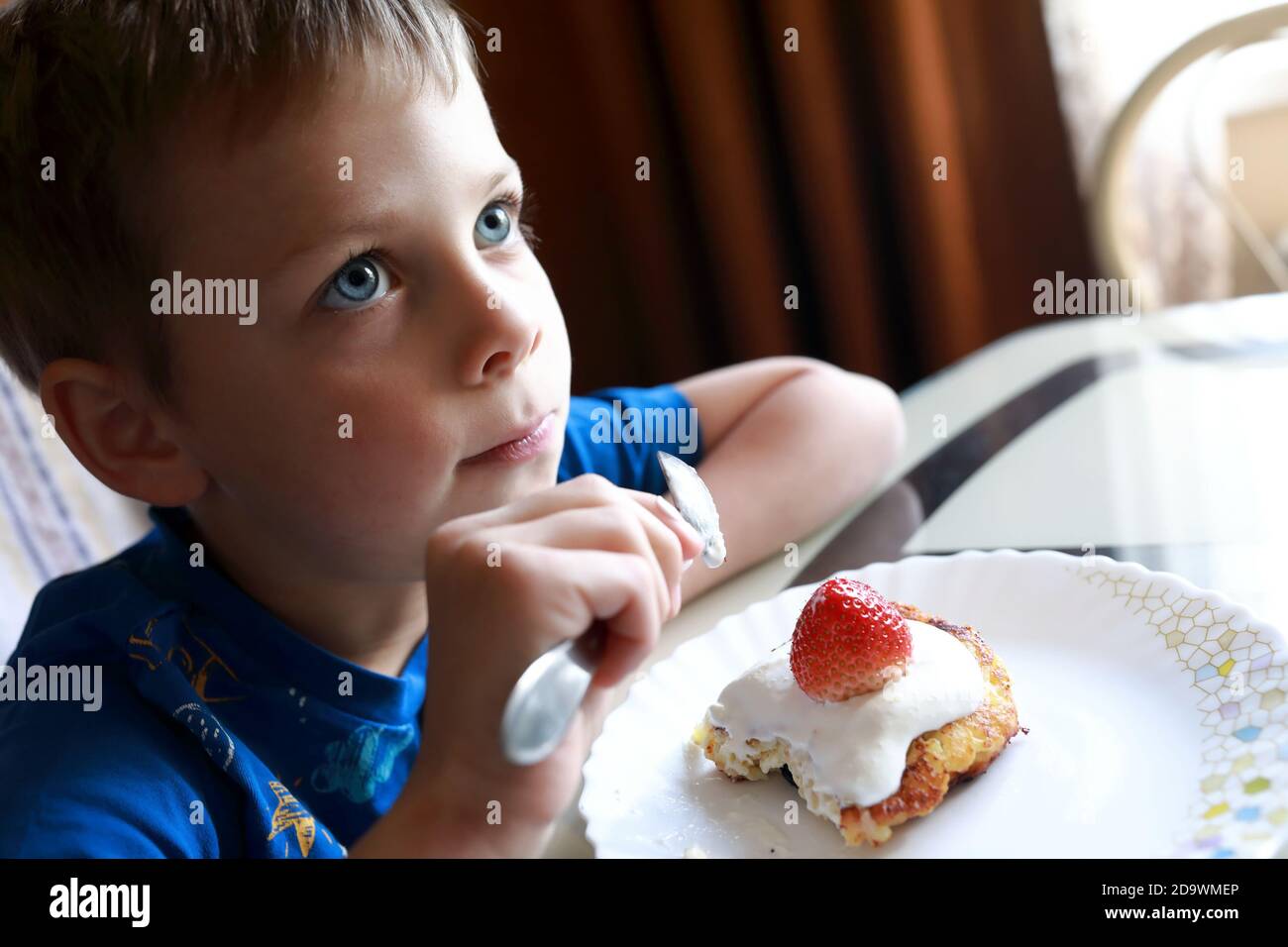 Child eating cheese pancake with strawberry at home Stock Photo - Alamy