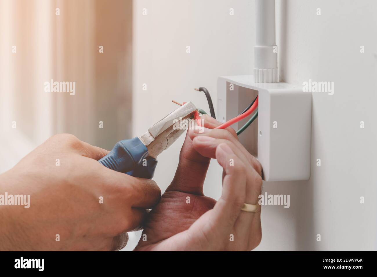 The technician is using a pliers wrench to install the power plug on ...