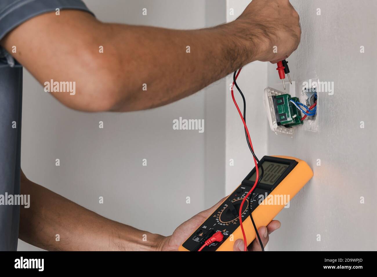 Man checking wall socket electric current hi-res stock photography and ...