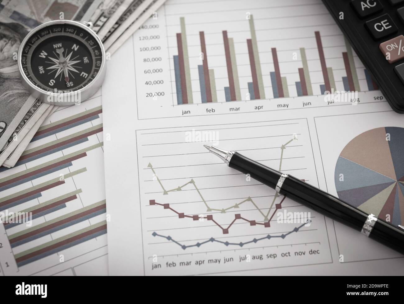 Pen on diagram chart and graphs business report with money, compass ...