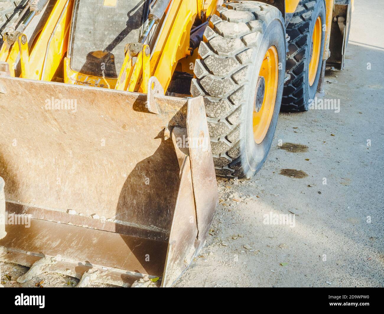 Fragment of a soiled yellow bulldozer with wheels and a ladle Stock ...