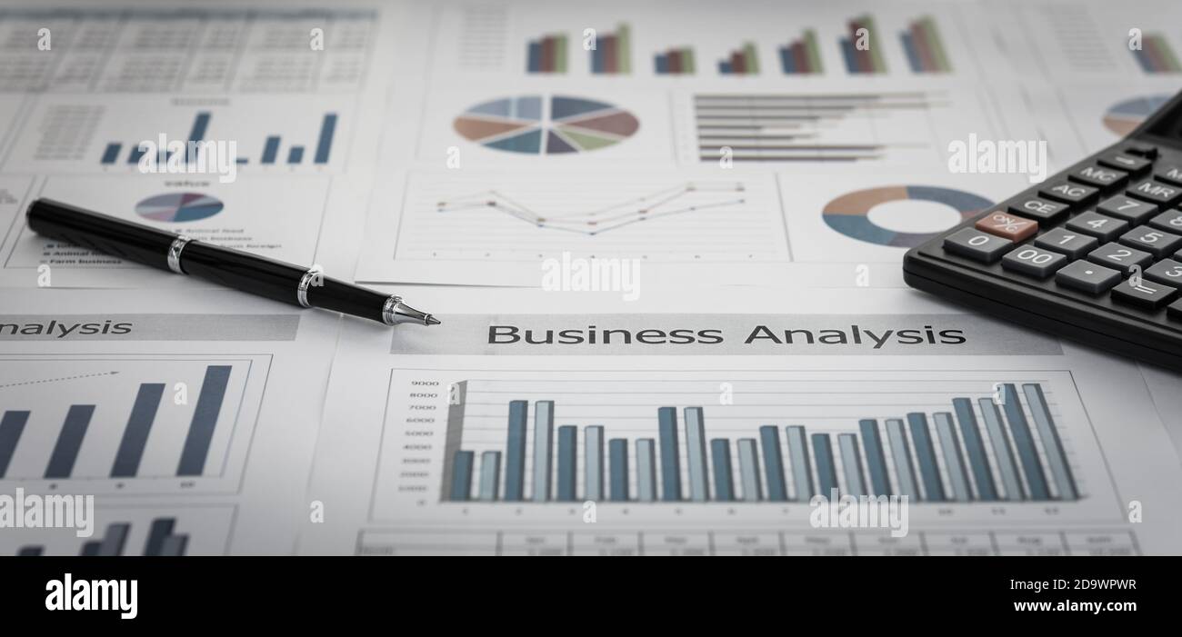 Business graphs and charts report with pen, calculator on desk of ...
