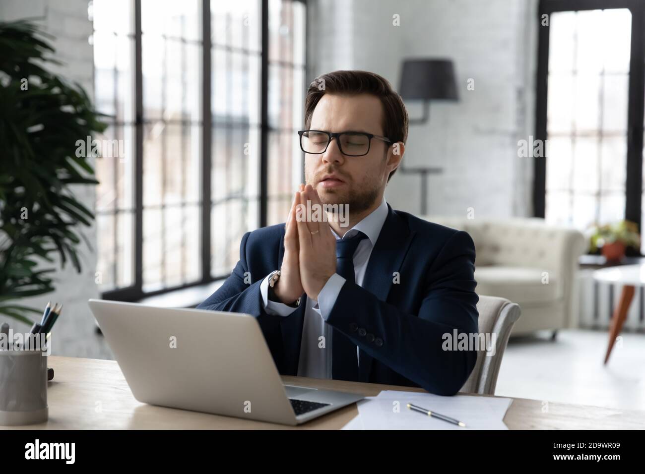 Hopeful young businessman praying God for good luck Stock Photo - Alamy