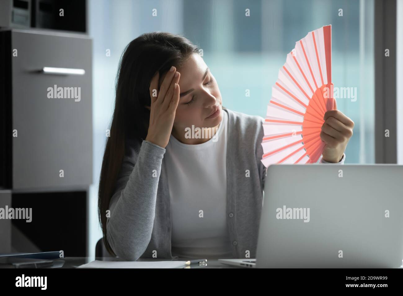 Sad female employee losing motivation because of heat in office Stock ...
