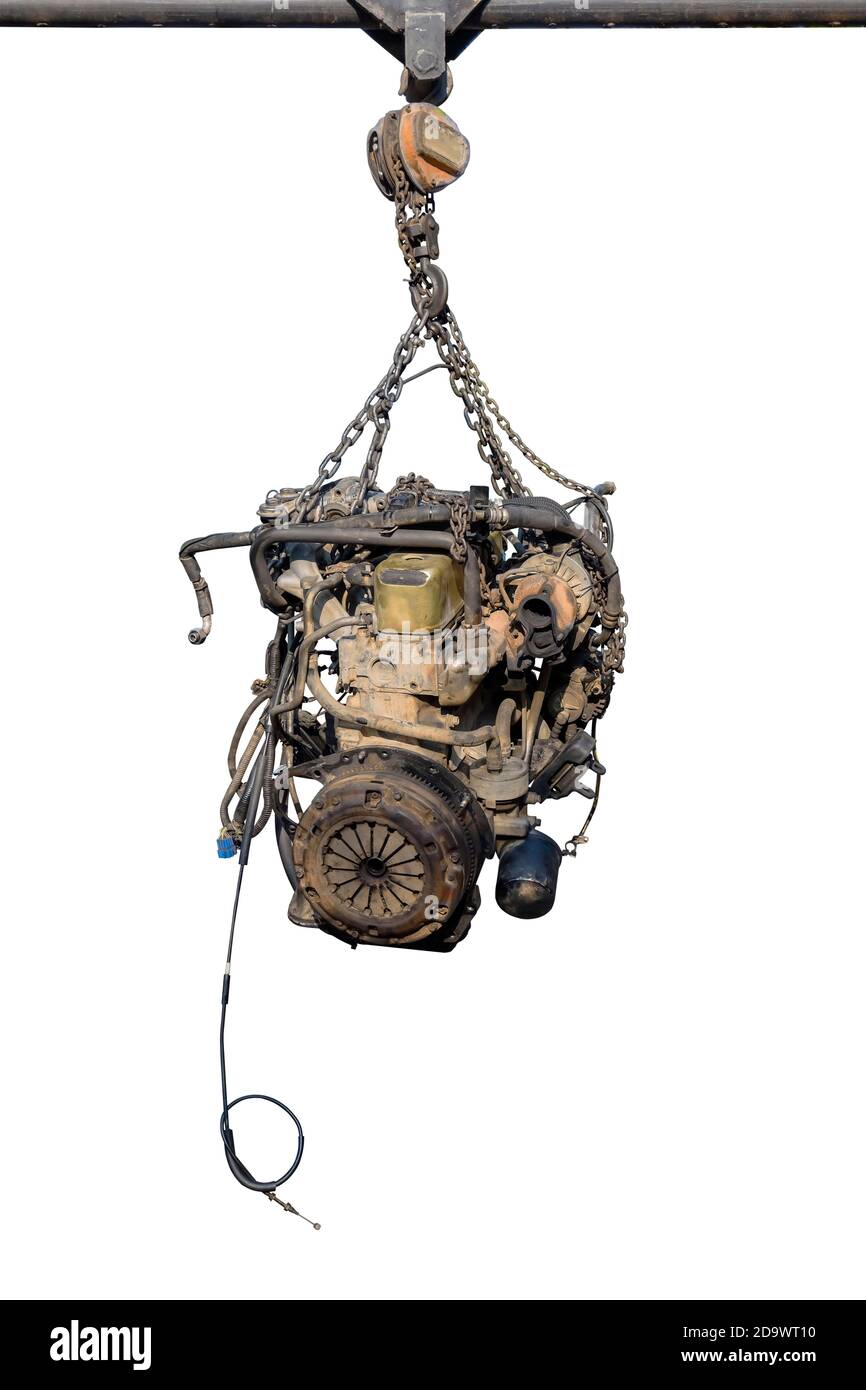 Old or used car engine hanging on the crane isolated on white ...