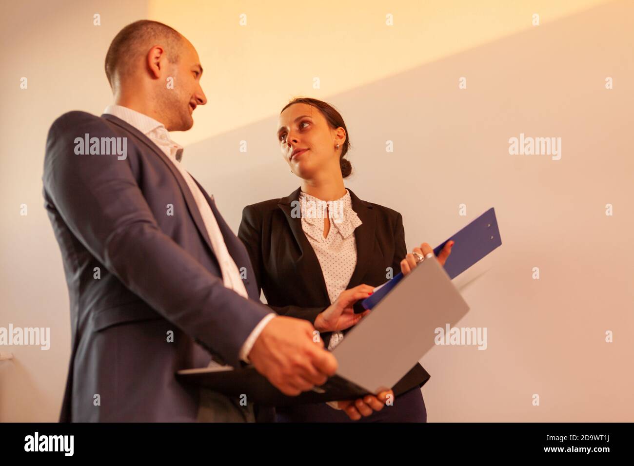 Businesswoman talking with corporate executive manager on staircase of ...