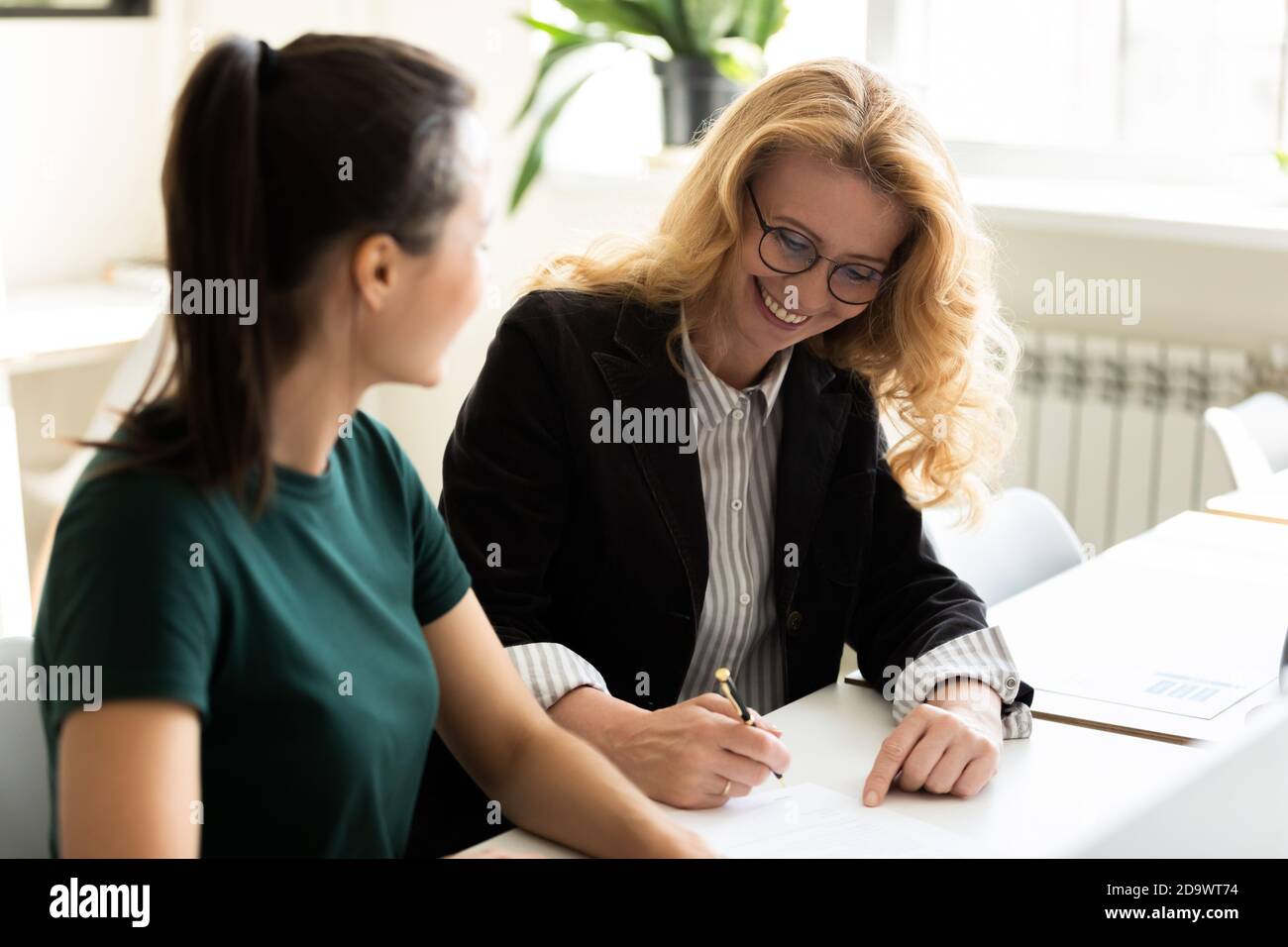 Satisfied older and younger female business partners concluding ...