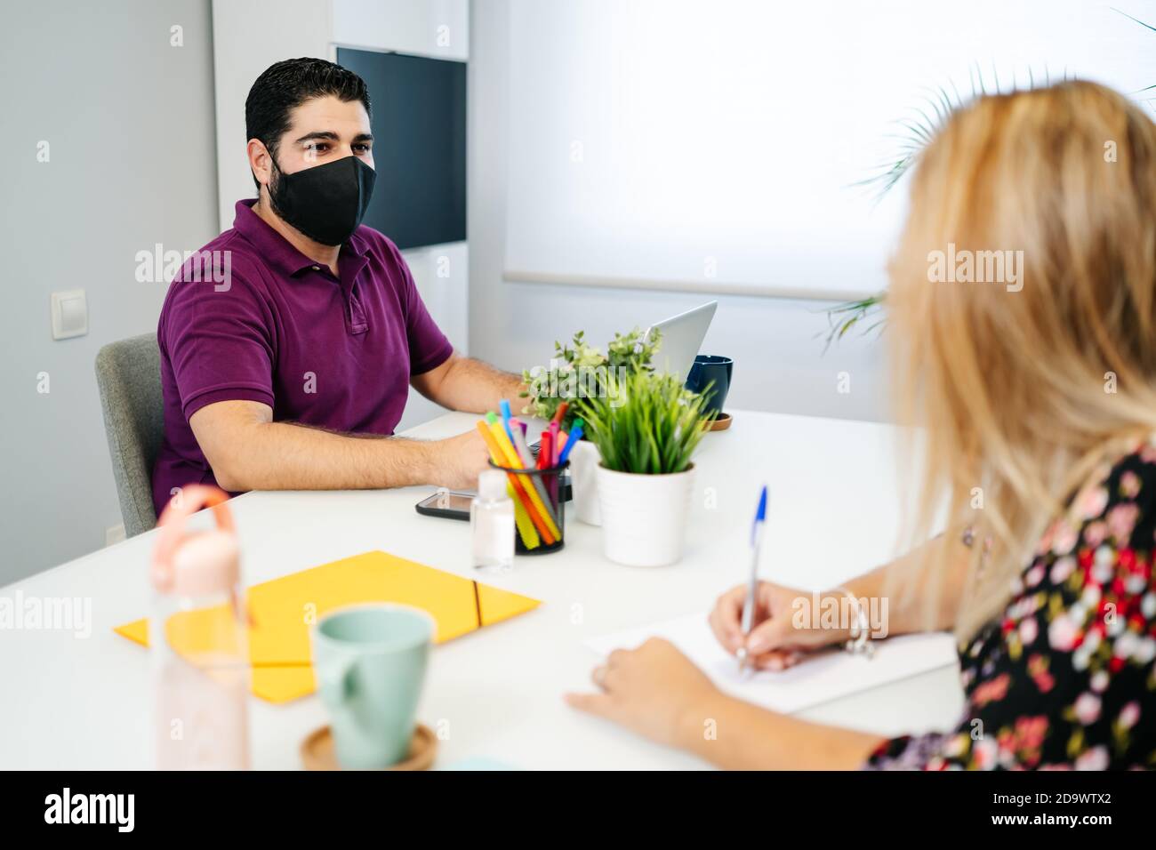 Man and woman working in a workspace keeping social distance in a safe ...