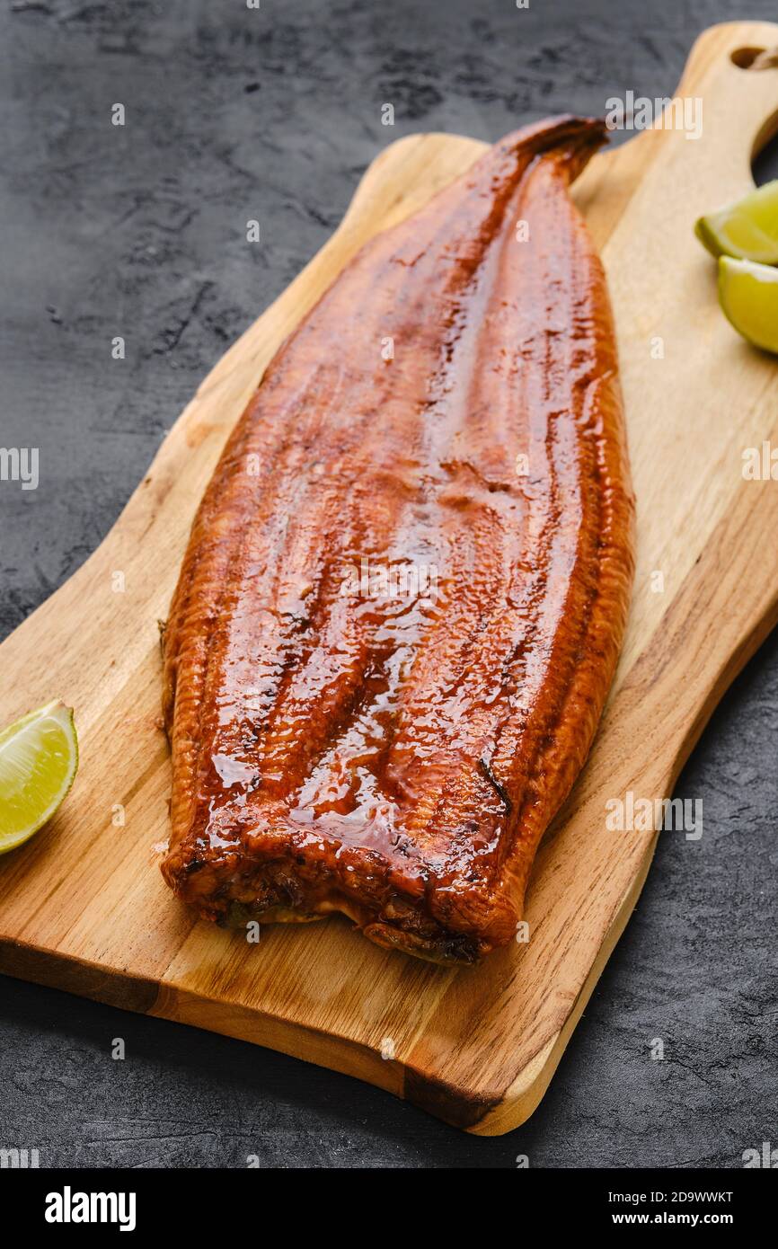 Whole smoked eel on wooden cutting board Stock Photo - Alamy