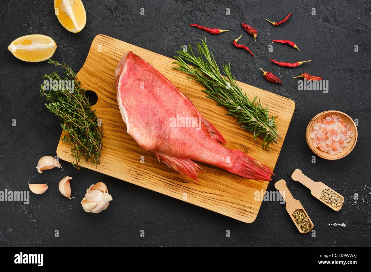 Top view of fresh frozen headless ocean perch with spice and herbs ...