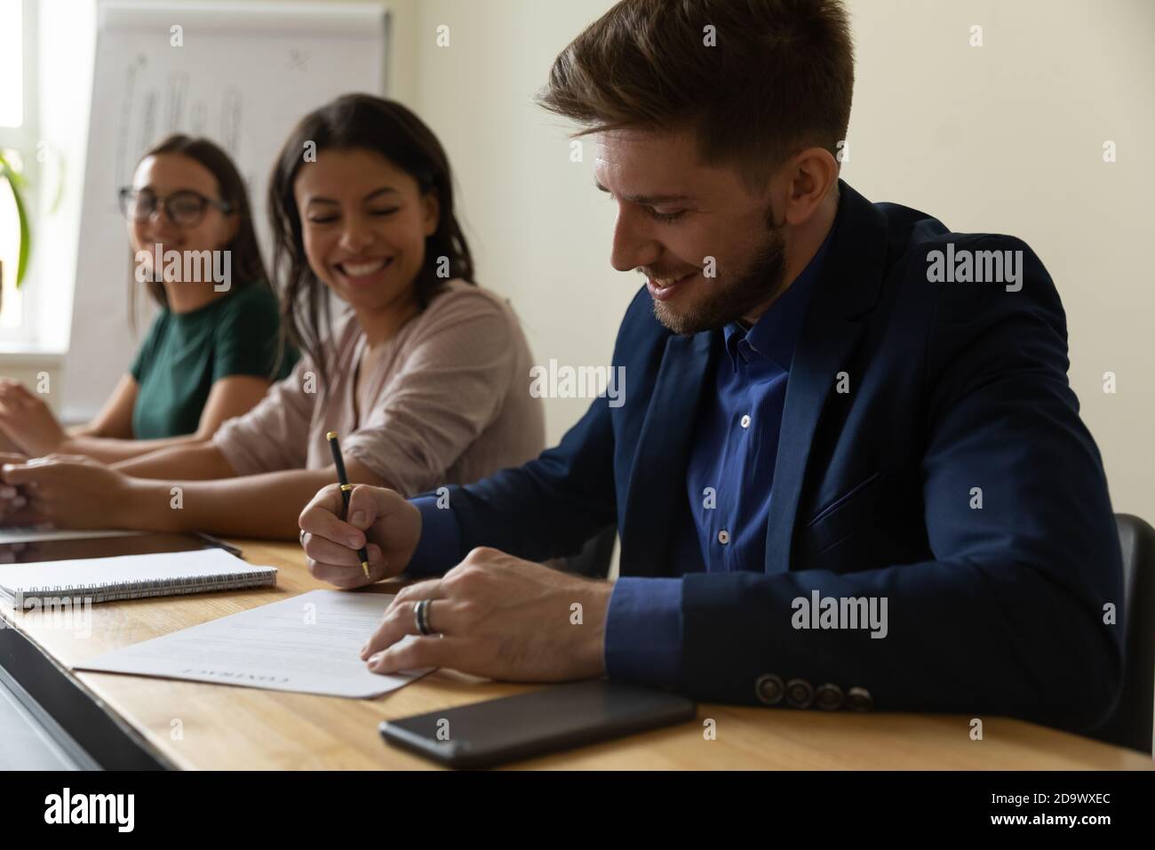 Happy young male employee signing job contract being hired Stock Photo ...