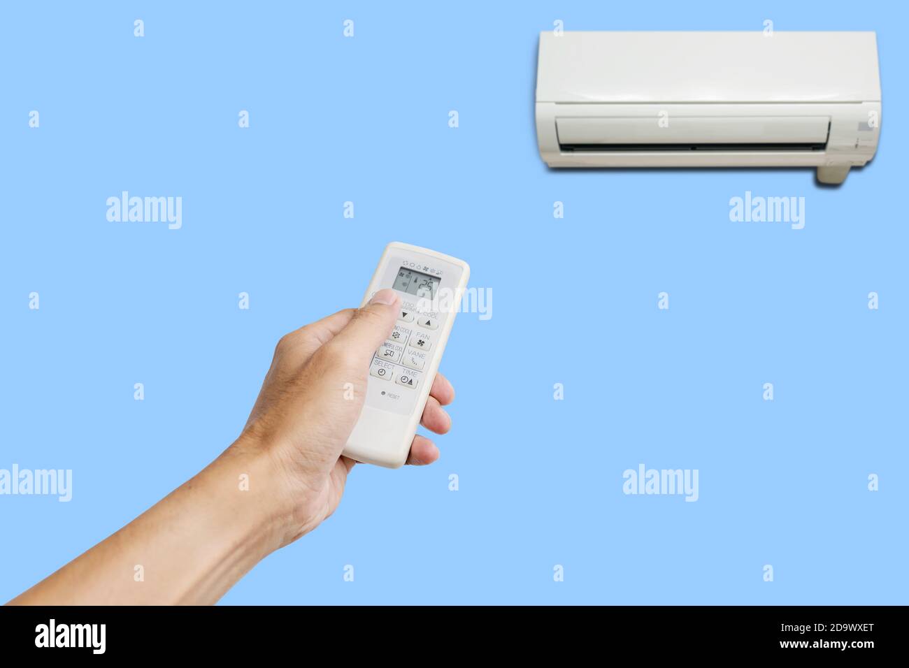 Hand holding the remote control to control the air conditioning ...