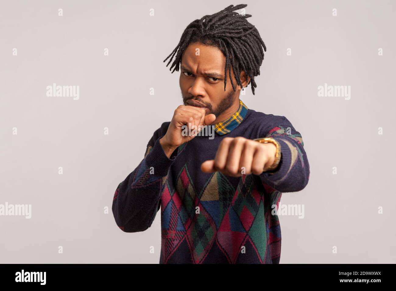 Confident concentrated african guy with dreadlocks and beard holding ...