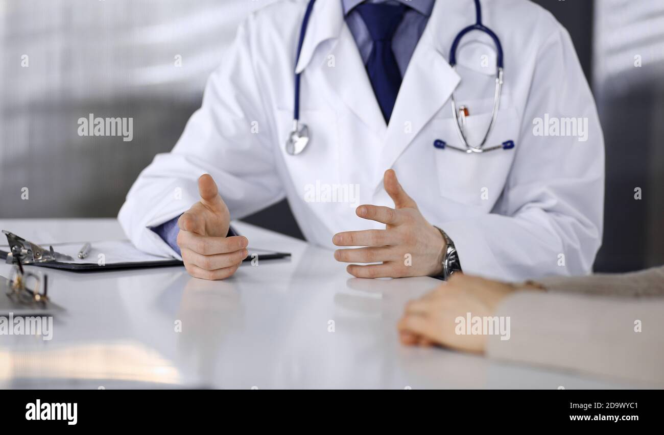 Unknown male doctor and patient woman discussing something while ...