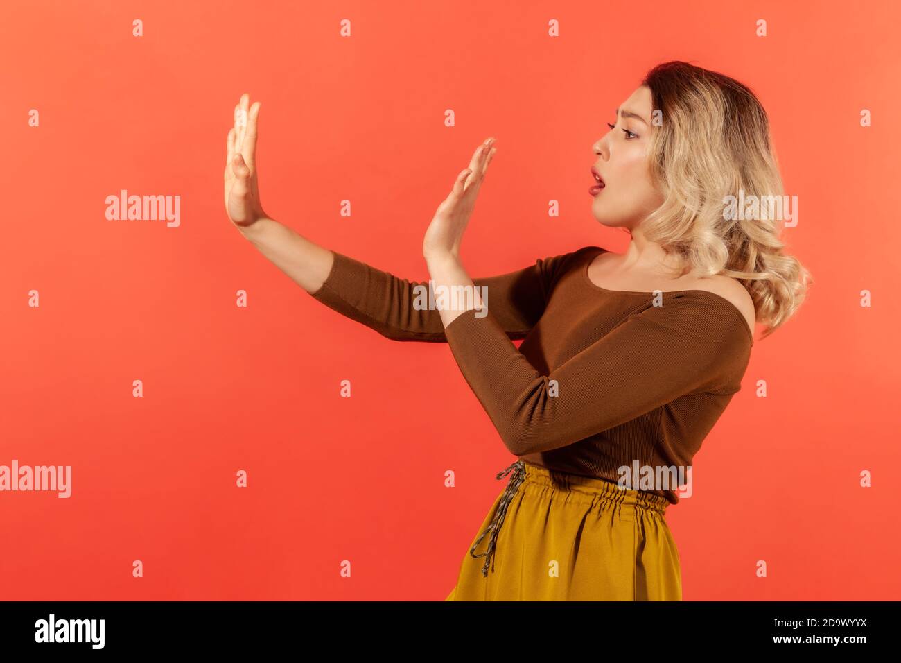 Side view portrait of scared woman with blonde hair in brown blouse ...