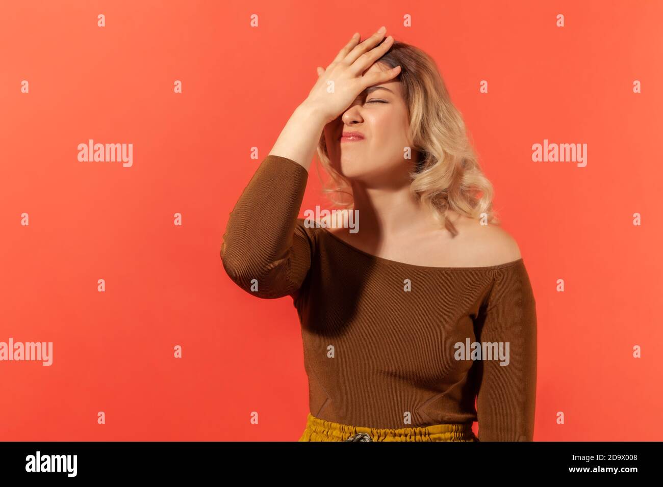 Facepalm. Portrait of unhappy young woman with blonde hair in casual ...