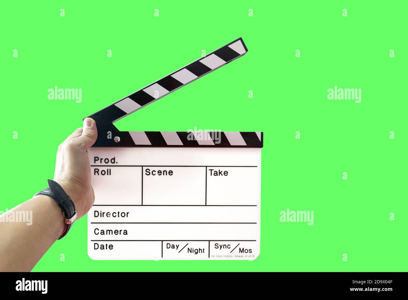 Men's hand holding camera slate for the filming isolated on green ...