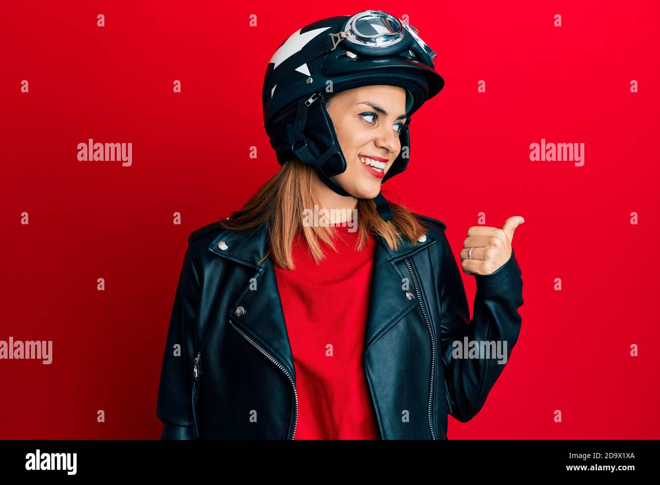 Hispanic young woman wearing motorcycle helmet smiling with happy face ...