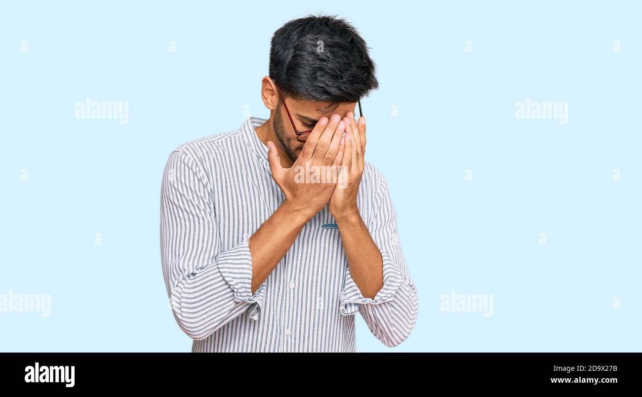 Young handsome man wearing casual clothes and glasses with sad ...