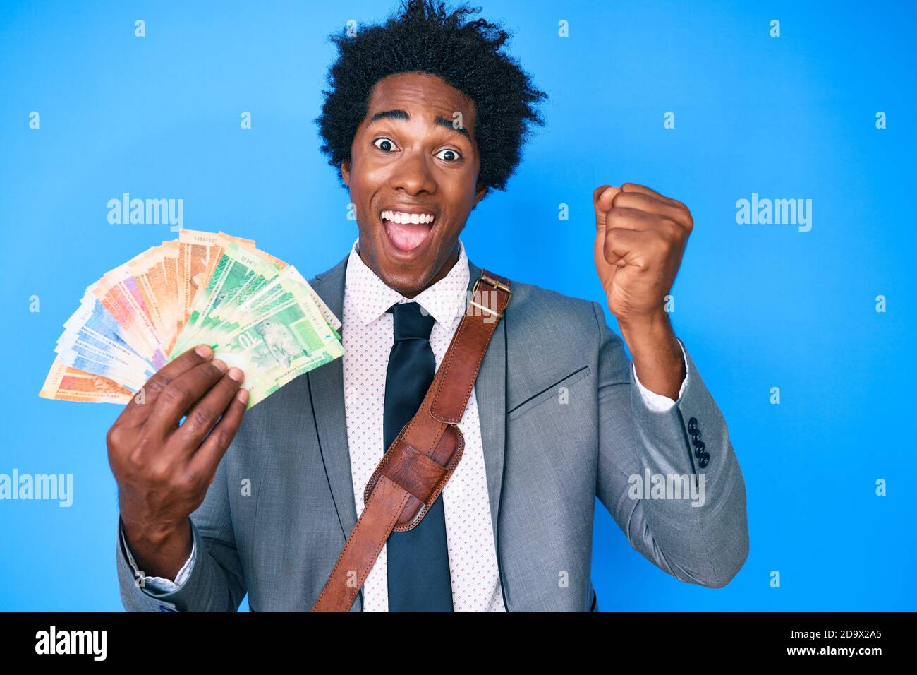 Handsome african american man with afro hair holding south african rand ...