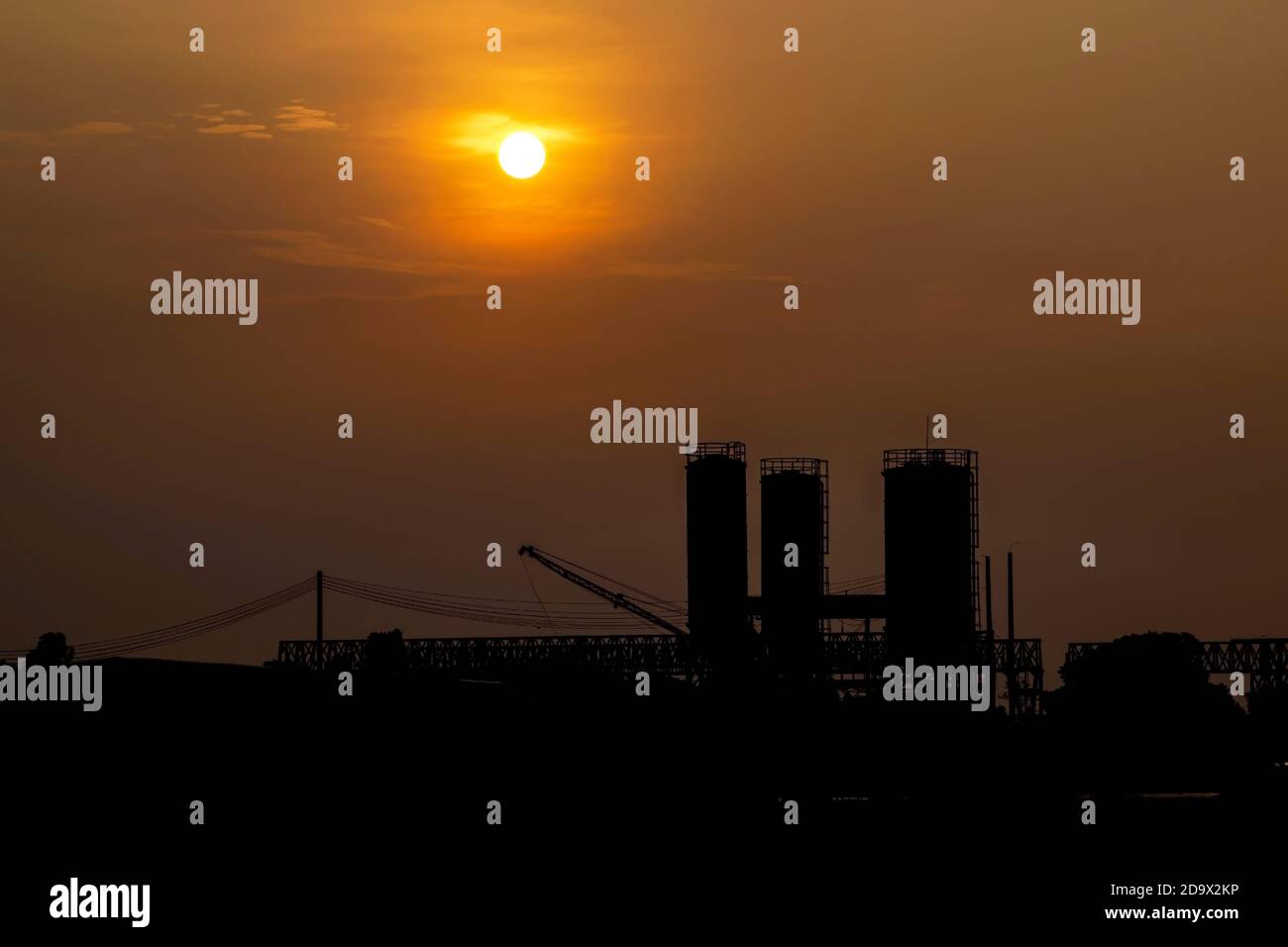 Beautiful sun and the red sky over the silhouette industrial factory ...